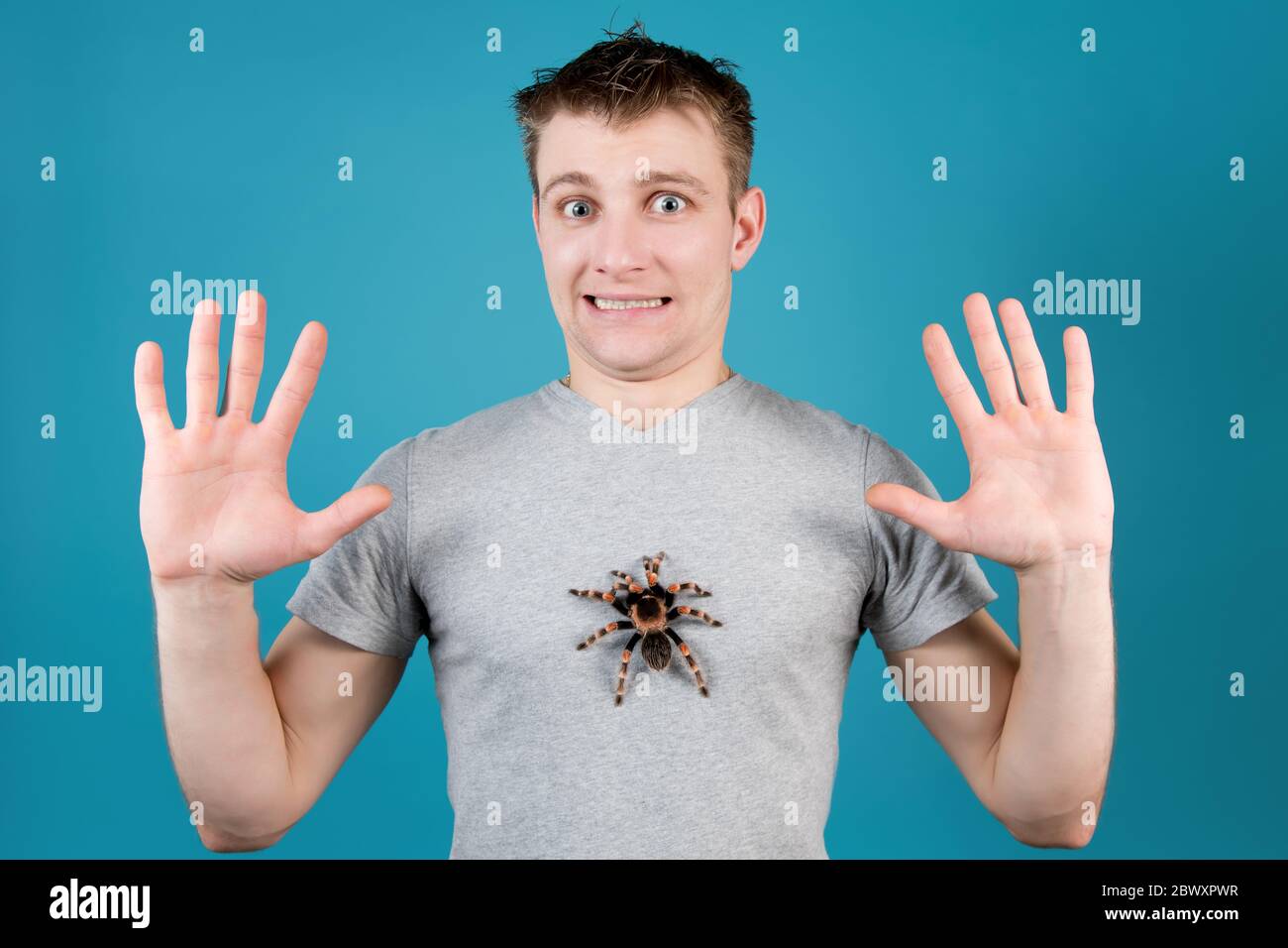 A young man spreads his arms to the sides and expresses the shock of ...