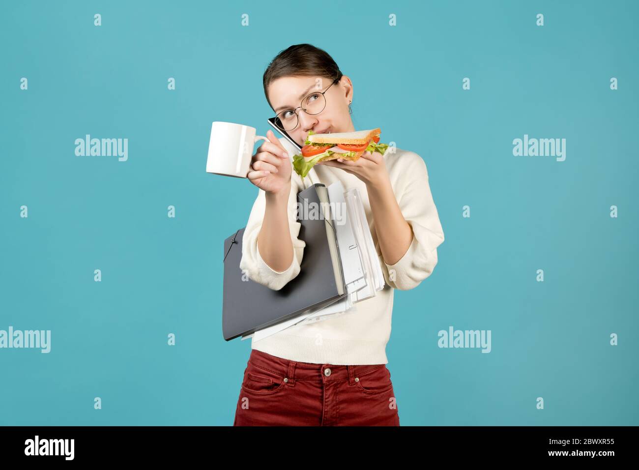 the junior office employee is inundated with work and eats on the go ...