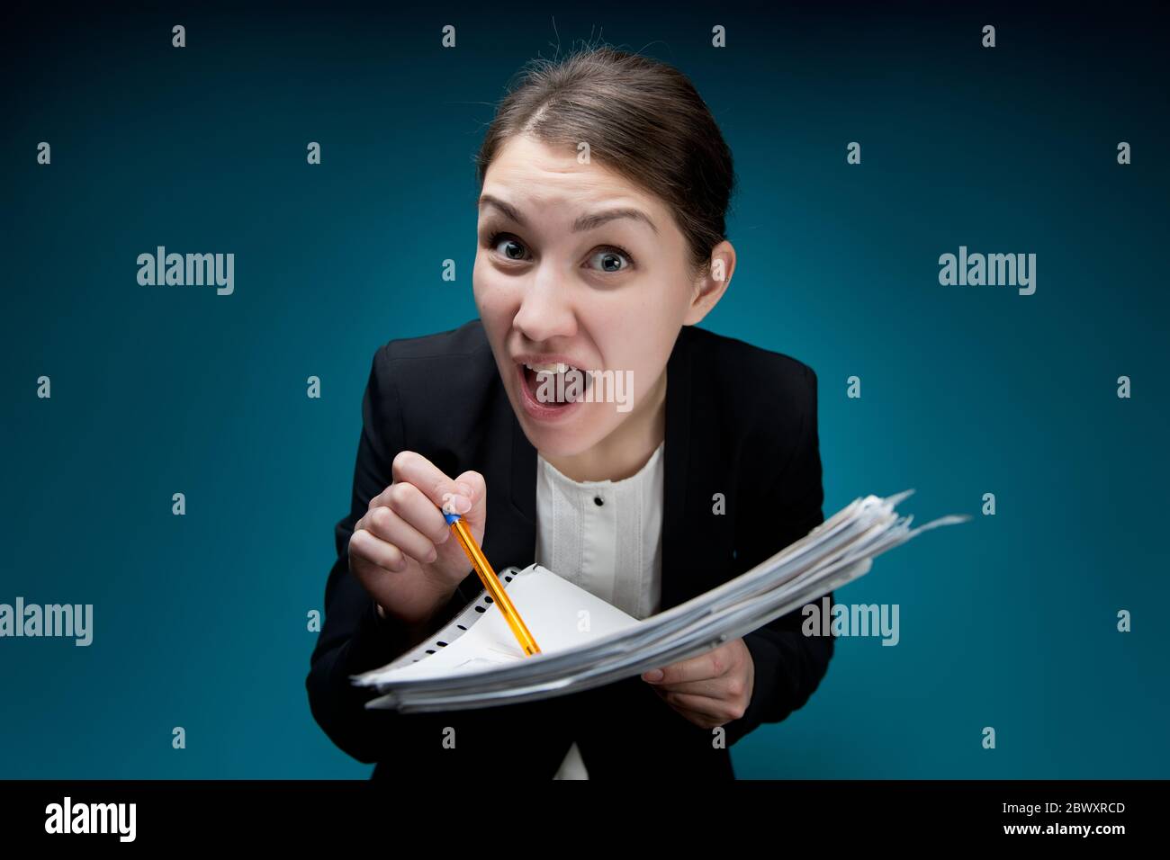 Strict female boss screaming, poking a pen into documents Stock Photo ...