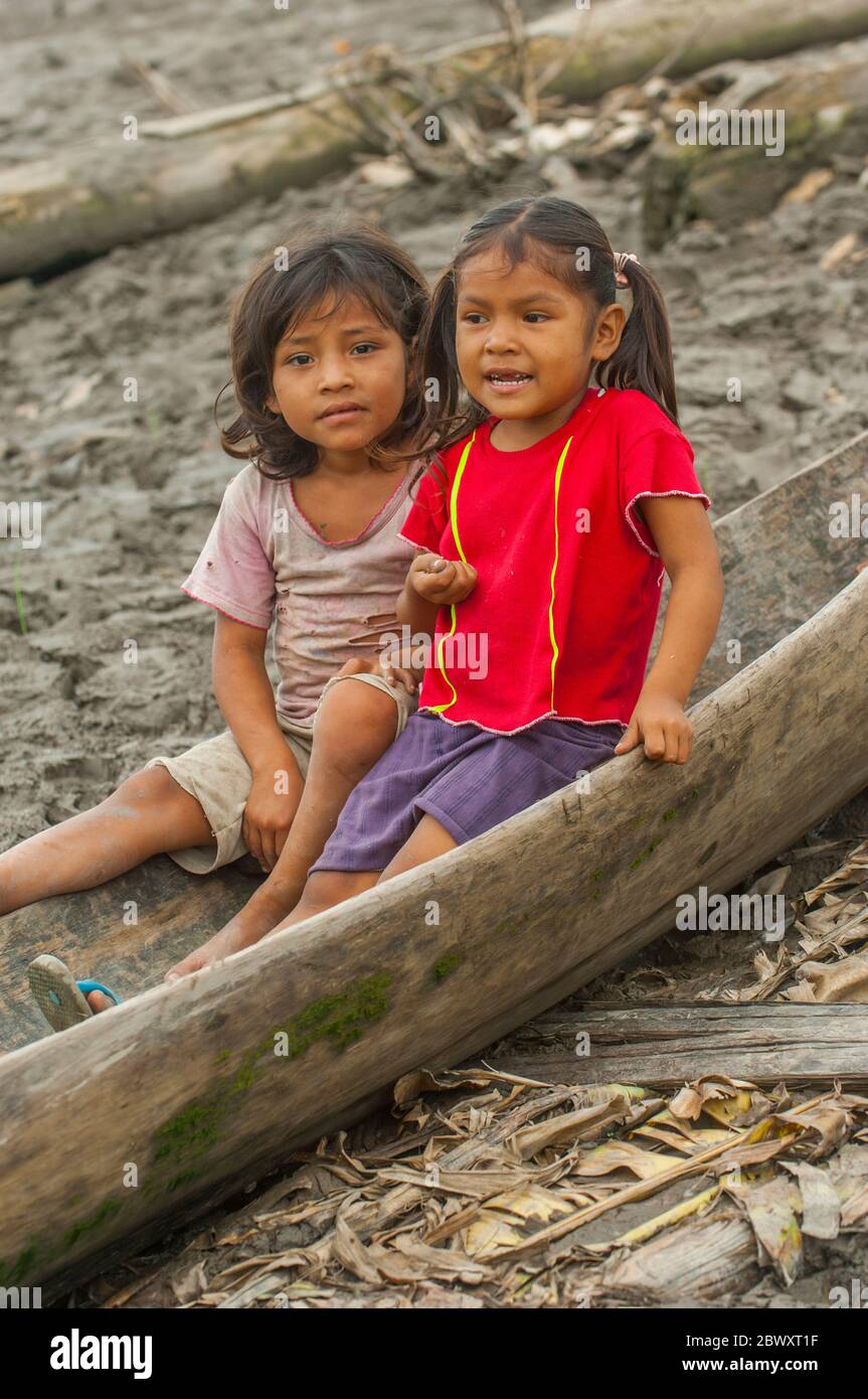 Two girls sitting in a canoe in a small village along the Maranon River ...
