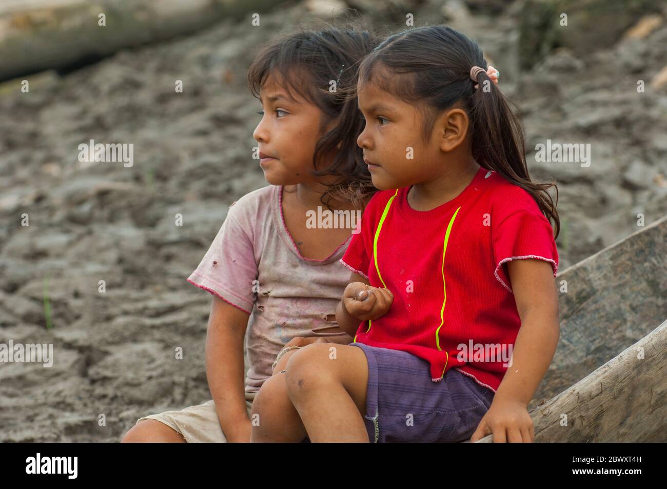 Two girls sitting in a canoe in a small village along the Maranon River ...