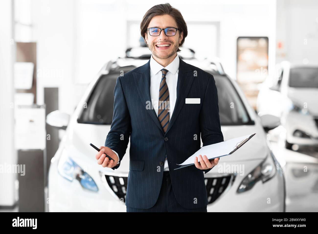 Salesman Standing In Dealership Center With Document Stock Photo - Alamy