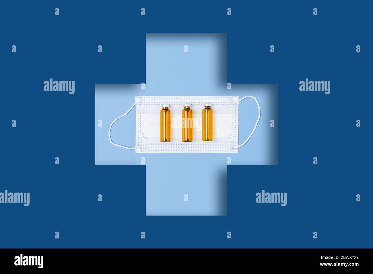 Medical blue background with three glass vials lying lying in a carved ...
