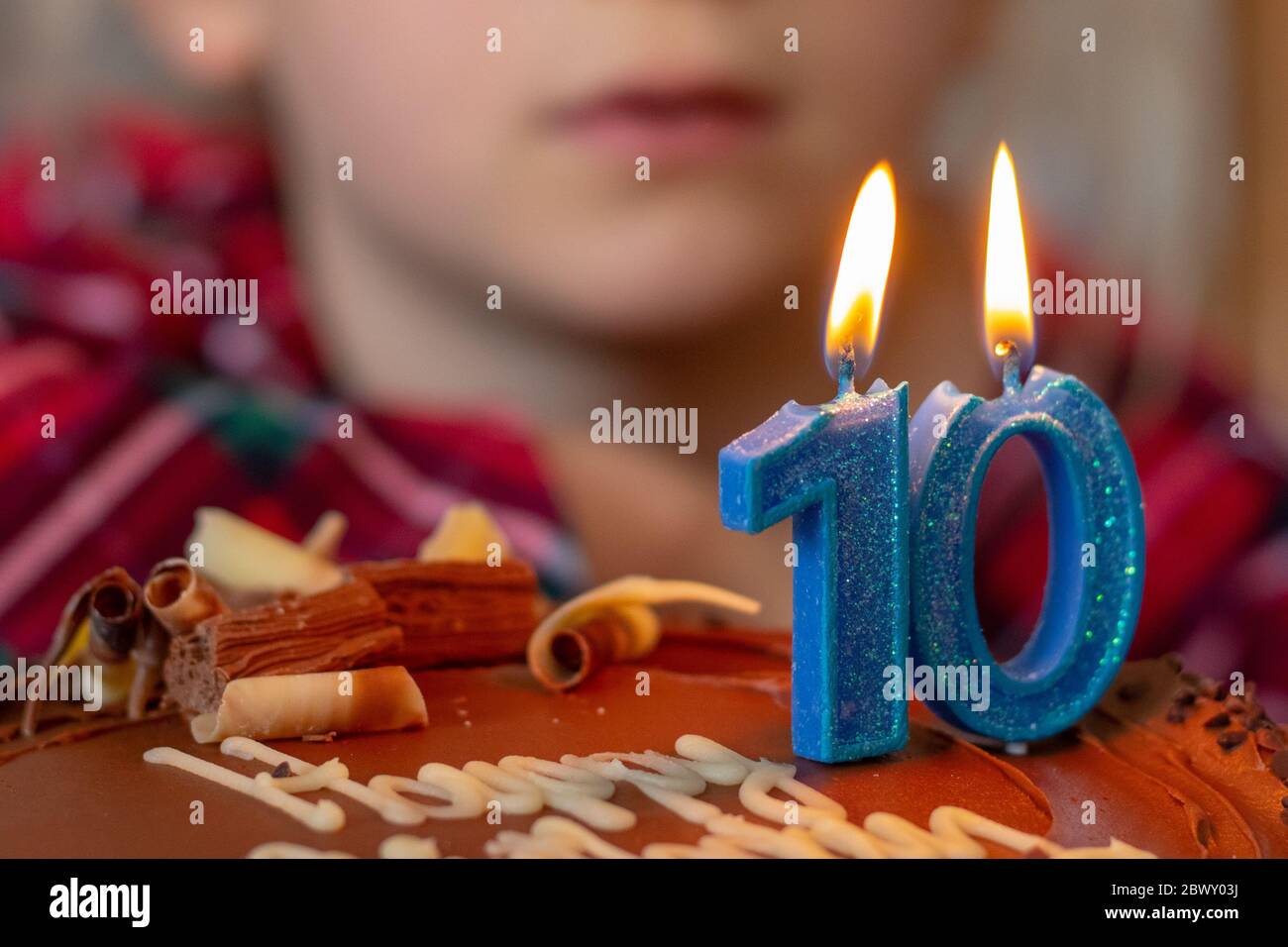 10th years B-day ,blue candles and kid in the background. Chocolate ...