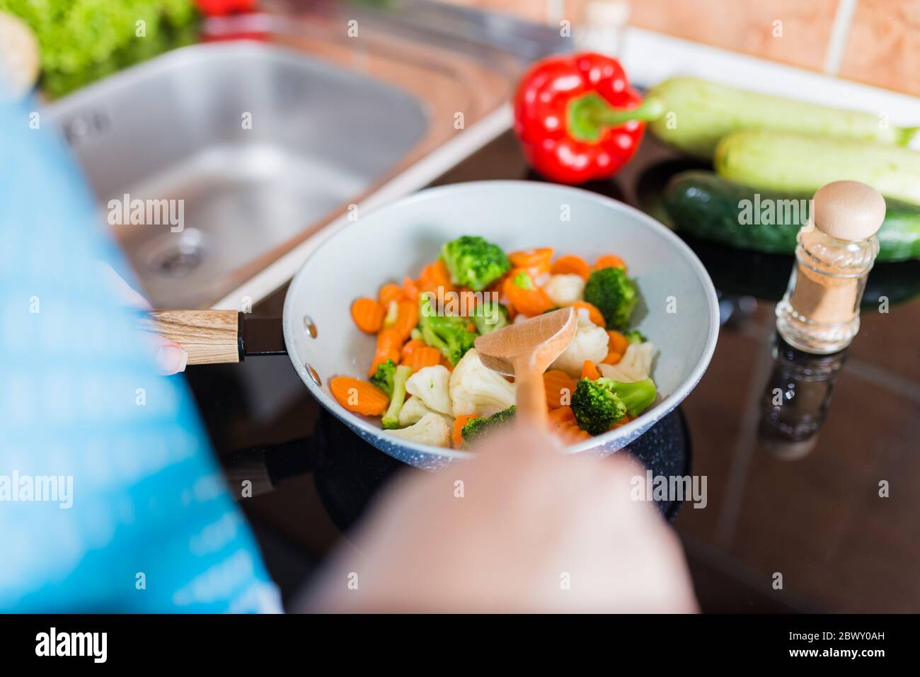 Woman frying vegetables in pan hi-res stock photography and images - Alamy
