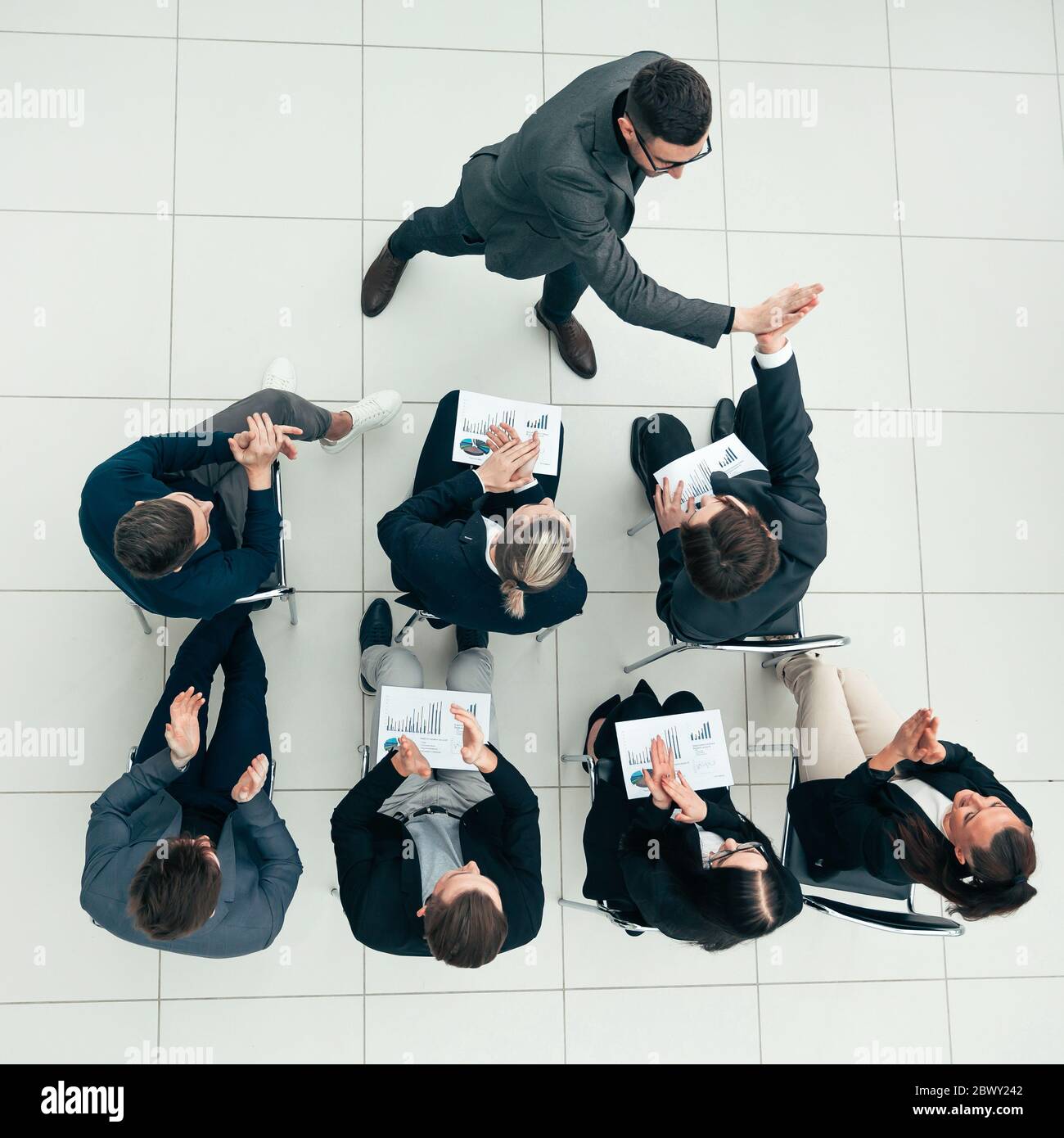 happy employees giving each other a high five at a work meeting Stock ...