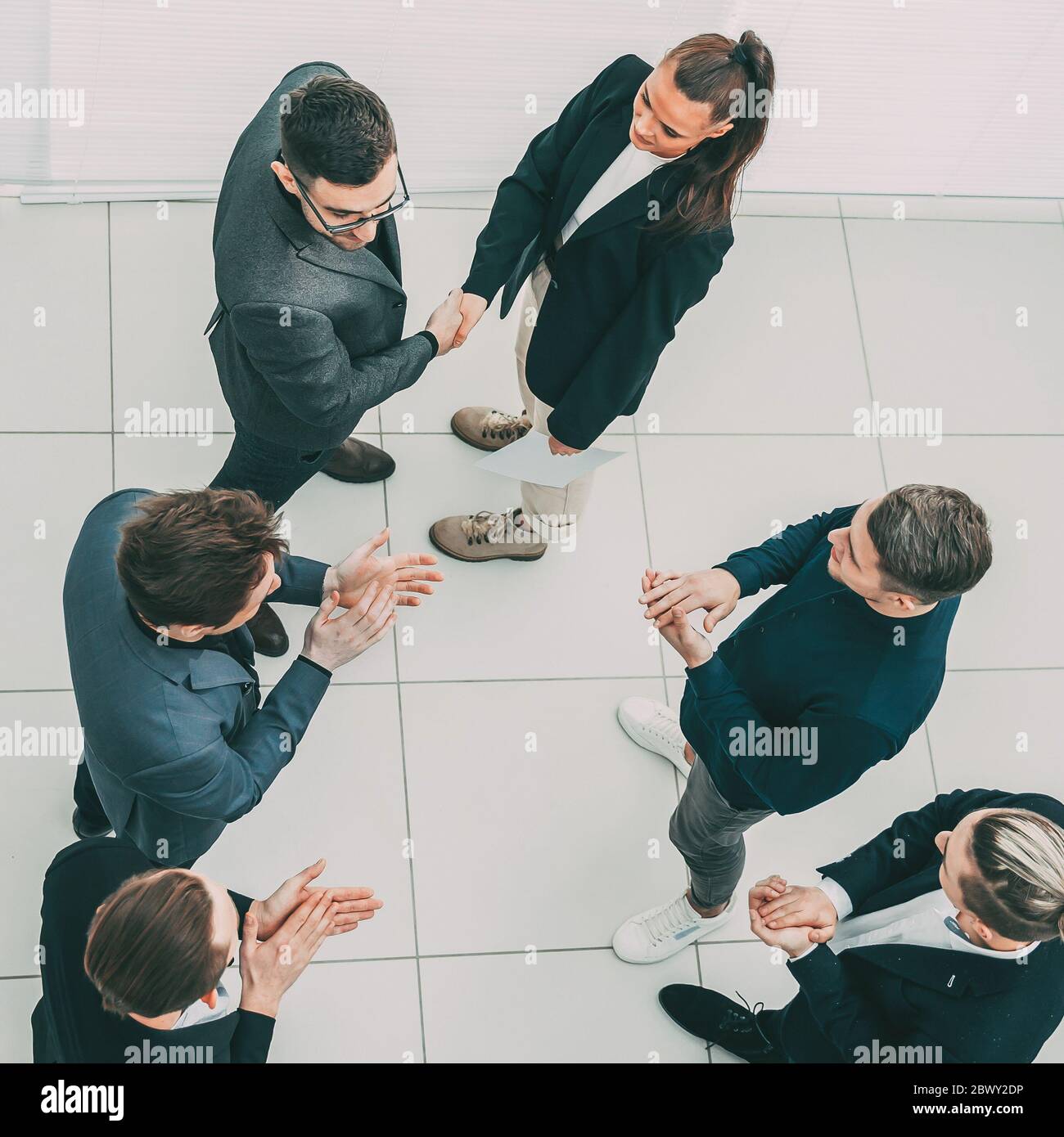 top view. boss shaking hands with a young employee Stock Photo - Alamy