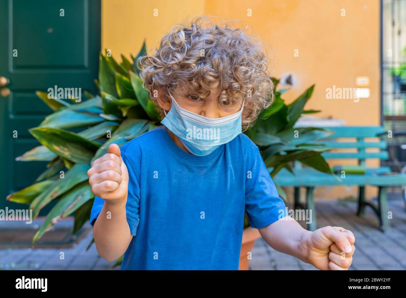happy kid with protective mask showing a victory sign during quarantine ...