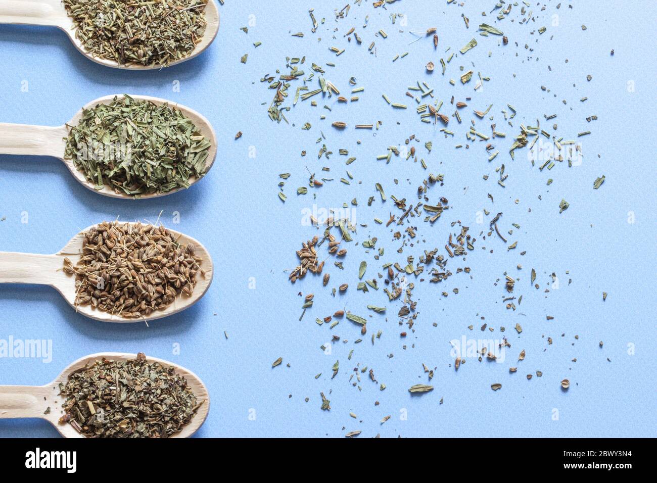 Collection of spices from herbs. Wooden spoons with spices laid out on ...