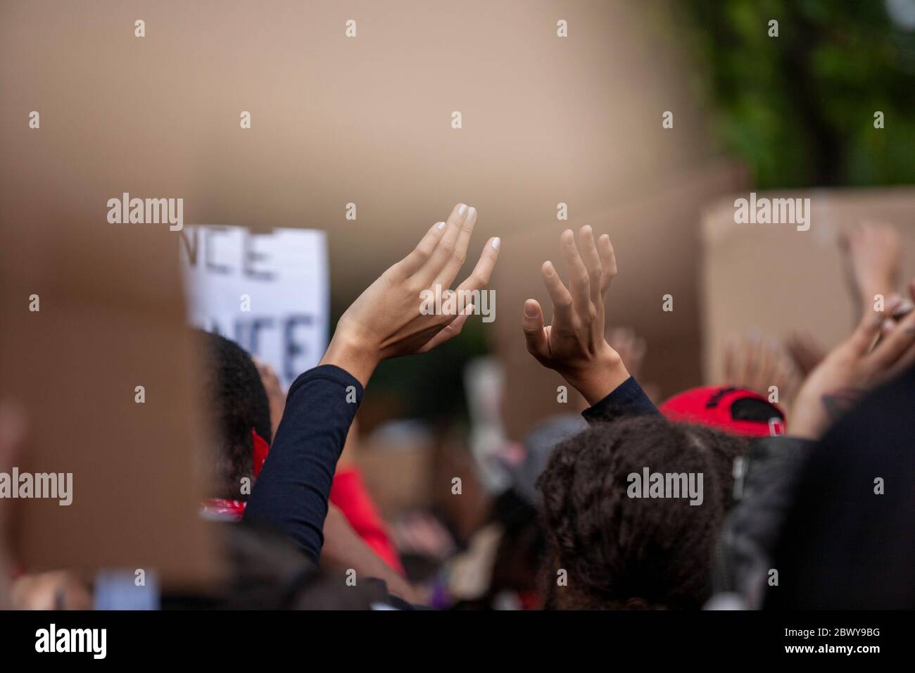 Young woman raising her arms in the air during the Black Lives Matter ...