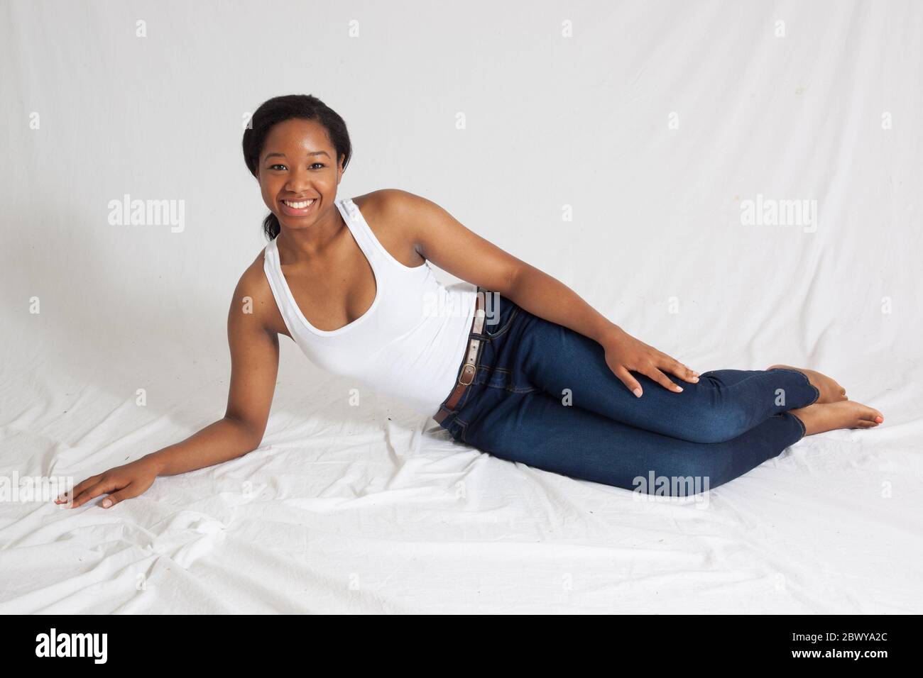 Happy Black woman reclining with a smile Stock Photo - Alamy