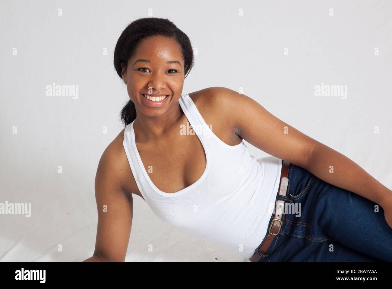 Happy Black woman reclining with a smile Stock Photo - Alamy
