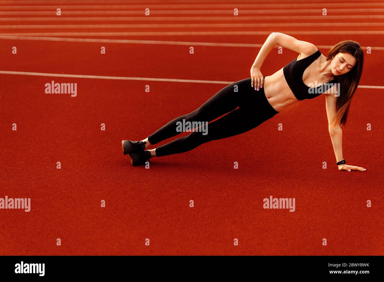 Wonderful fitness woman doing sport exercises in the stadium ...