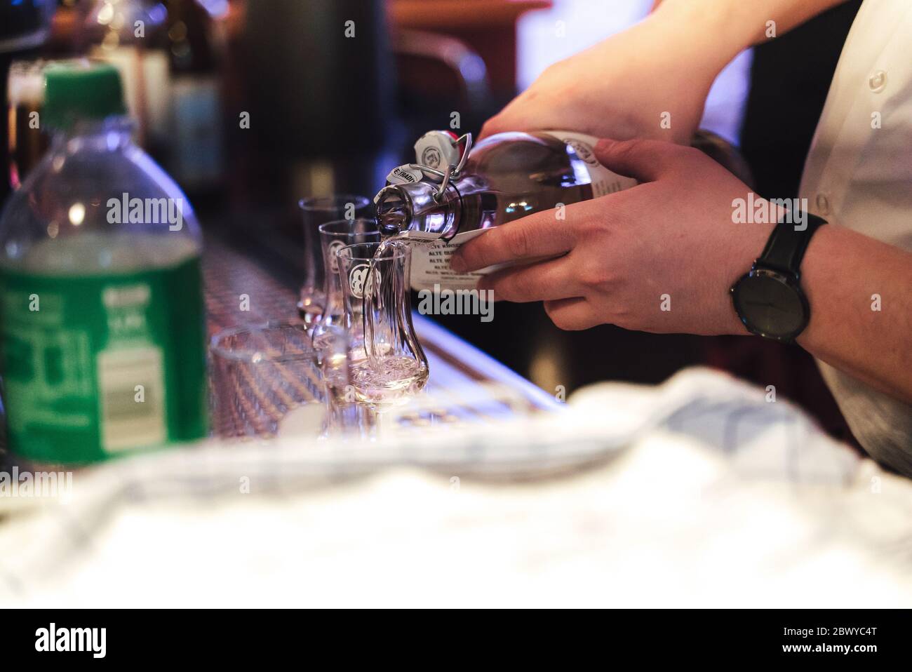 Man preparing drink at bar. Closeup of male hands pouring transparent ...