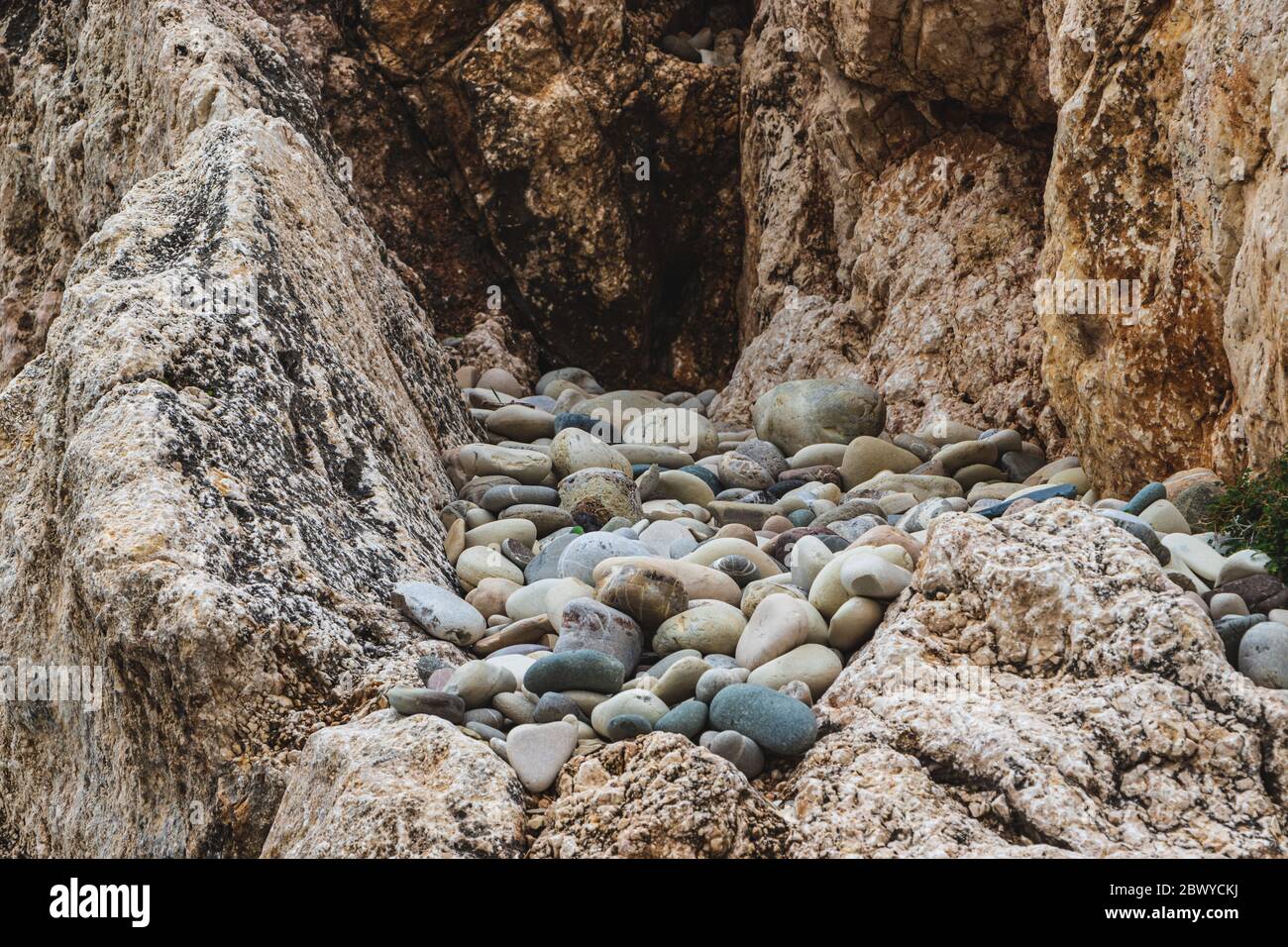 A close up view of smooth polished multicolored stones washed ashore on ...