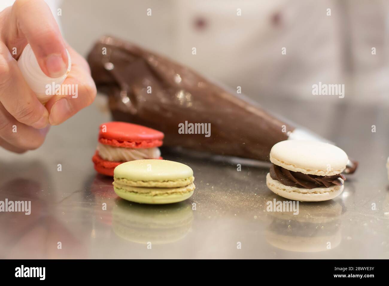 Detail of the preparation of macaron, french sweet food, inside a ...