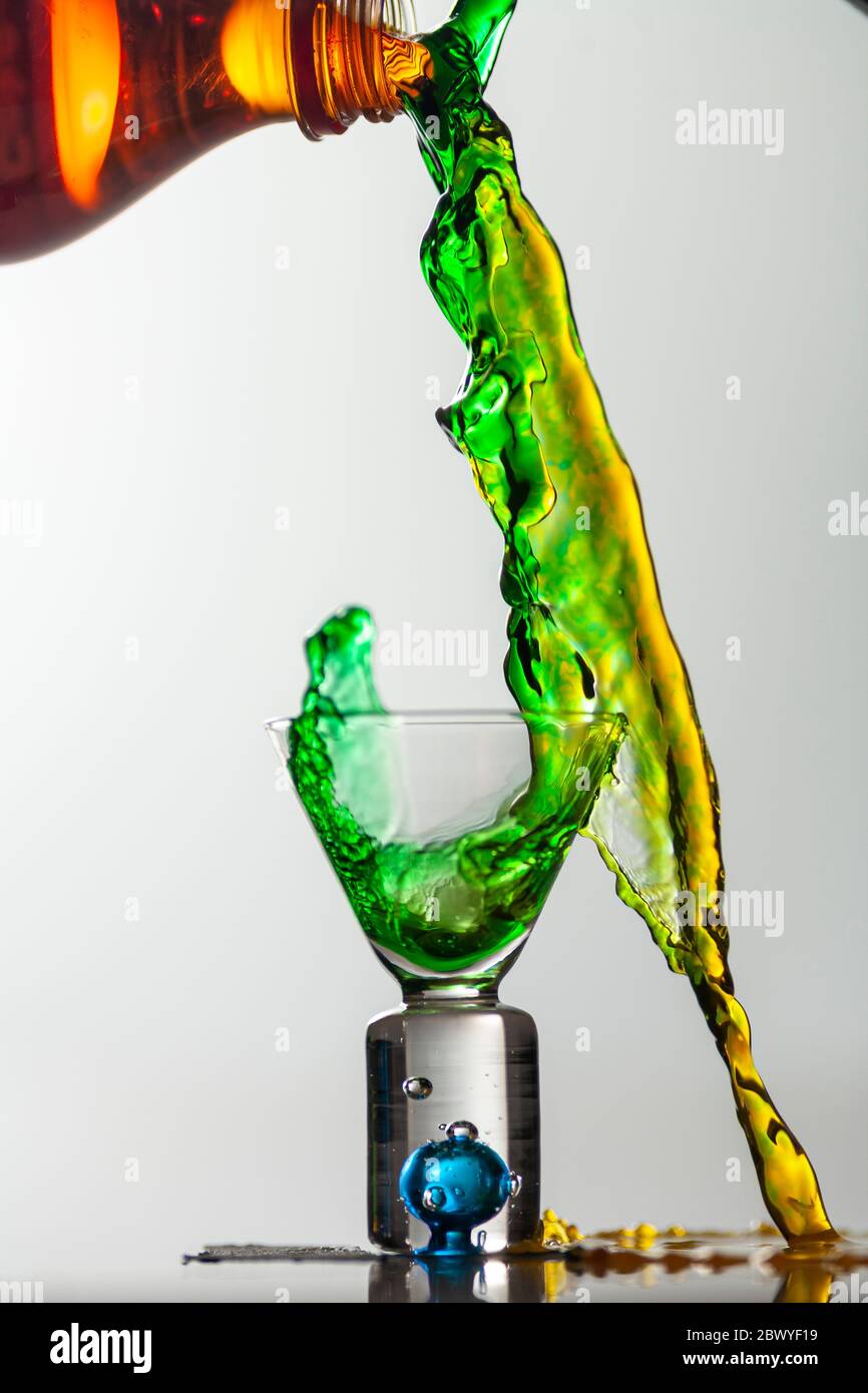 Pouring different color liquids into glasses Stock Photo - Alamy