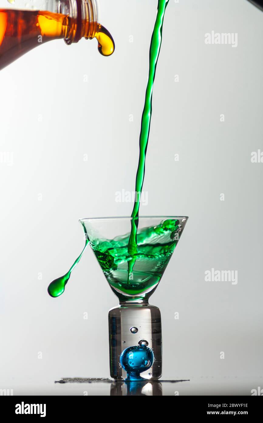 Pouring different color liquids into glasses Stock Photo - Alamy