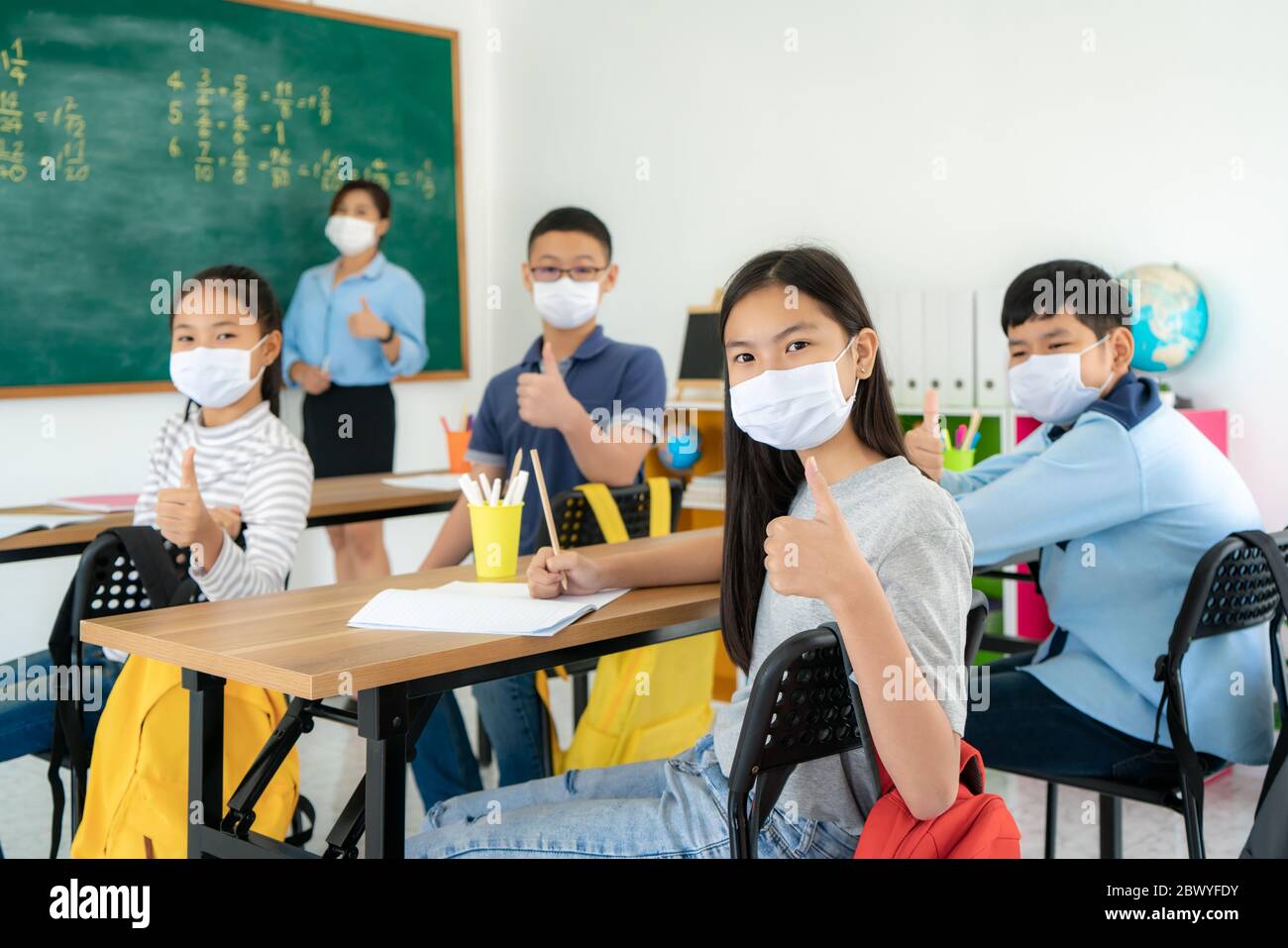 Group of Asian elementary school students and teacher wearing hygienic ...