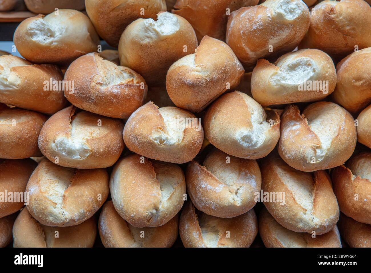different fresh bread on the shelves in bakery. Rows of fresh bread ...