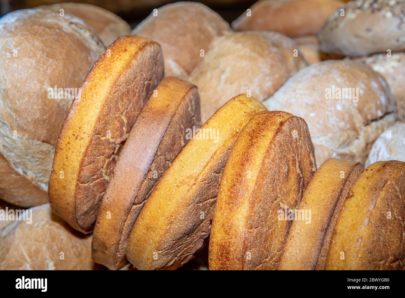 different fresh bread on the shelves in bakery. Rows of fresh bread ...