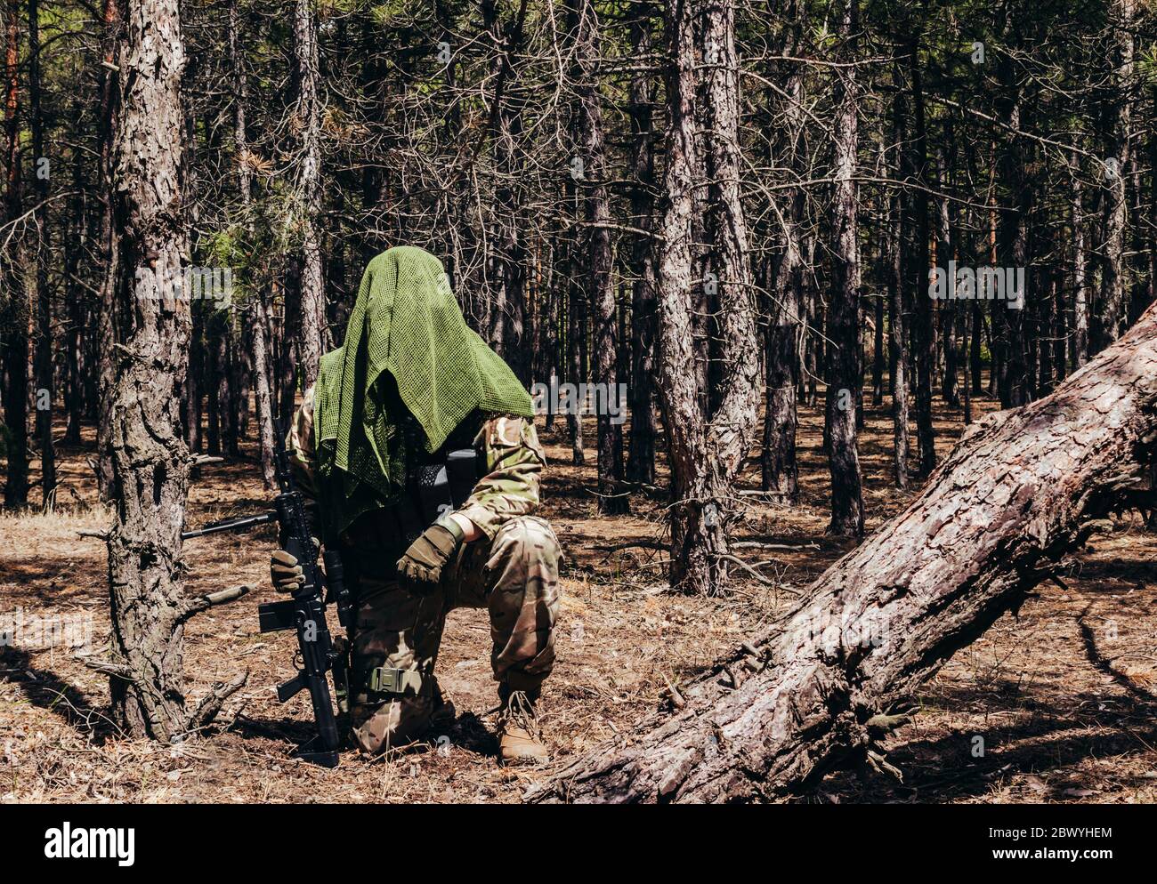 Photo of a fully equipped camouflaged forest sniper with rifle and ...