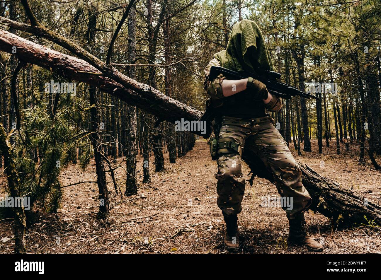 Photo of a fully equipped camouflaged forest sniper with rifle standing ...