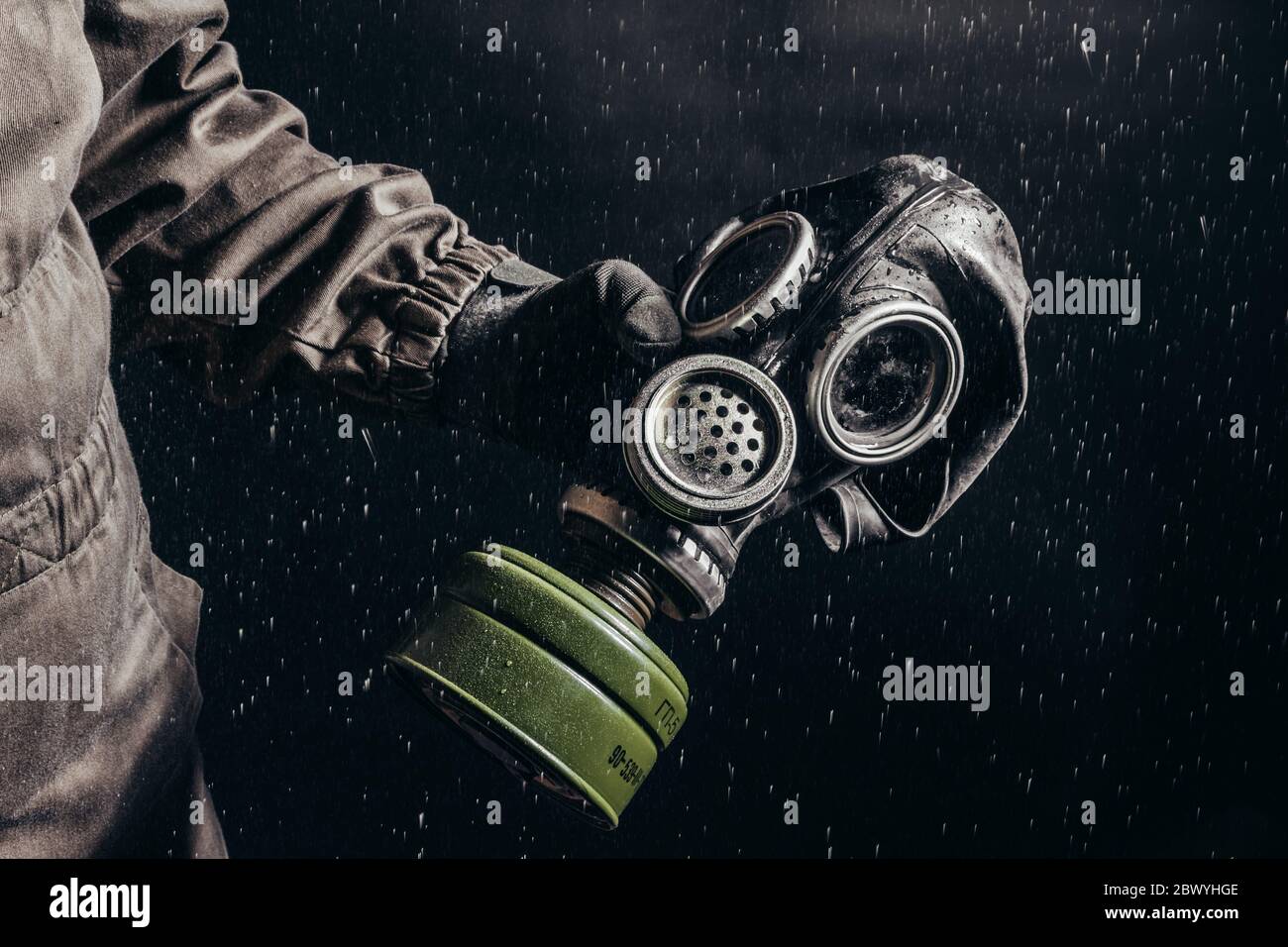 Photo of a stalker holding soviet gas mask during rain on black ...