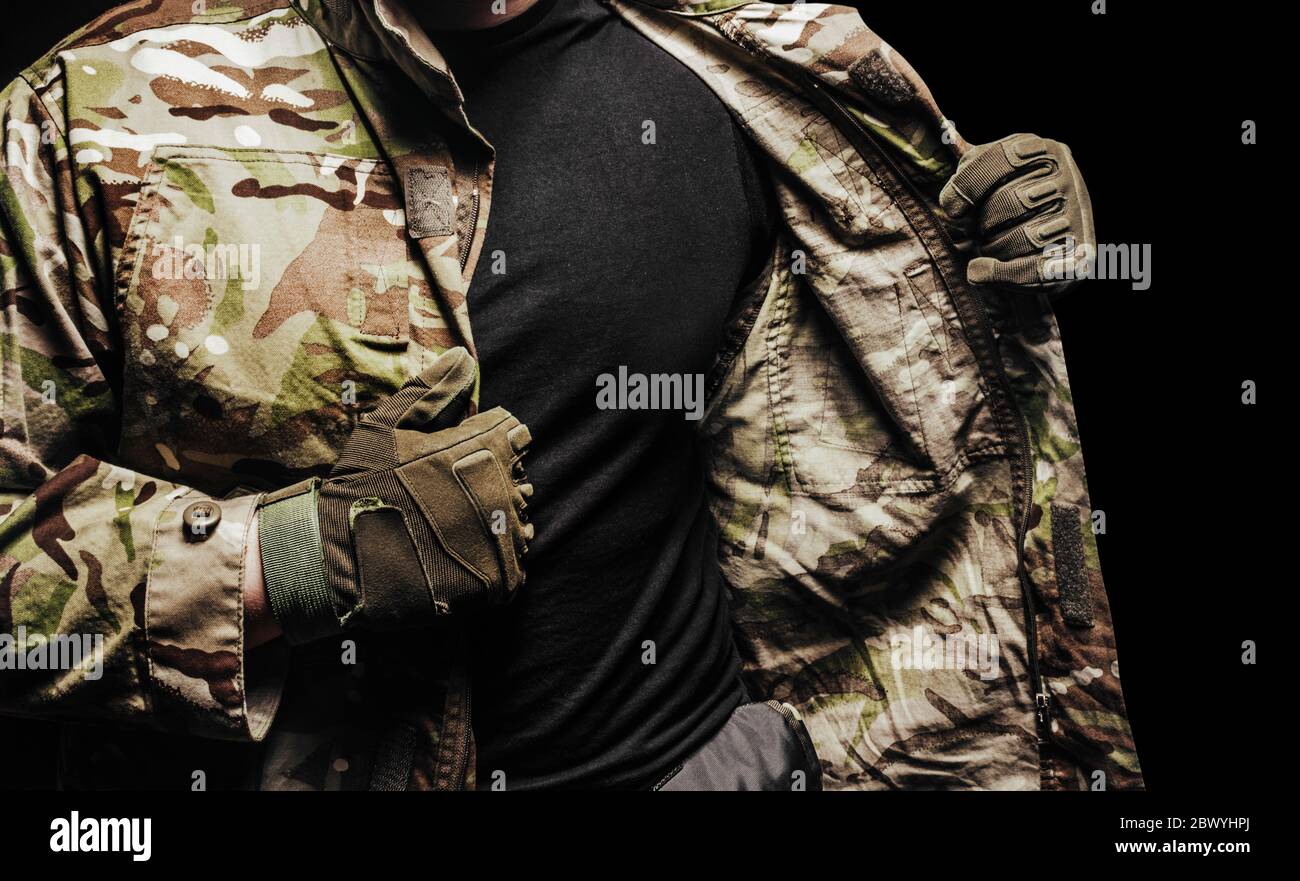 Photo of a soldier putting on multicam camouflage tunic on black ...