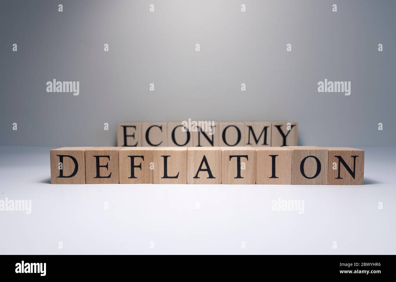 Deflation text from wooden cubes. Spot light in the studio and white ...