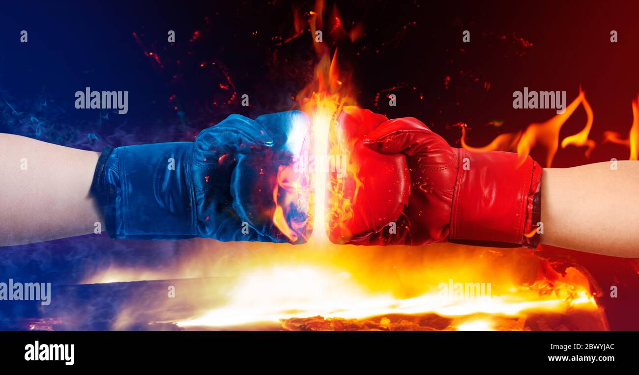 Photo of male hands in red and blue boxing gloves punching with fire ...