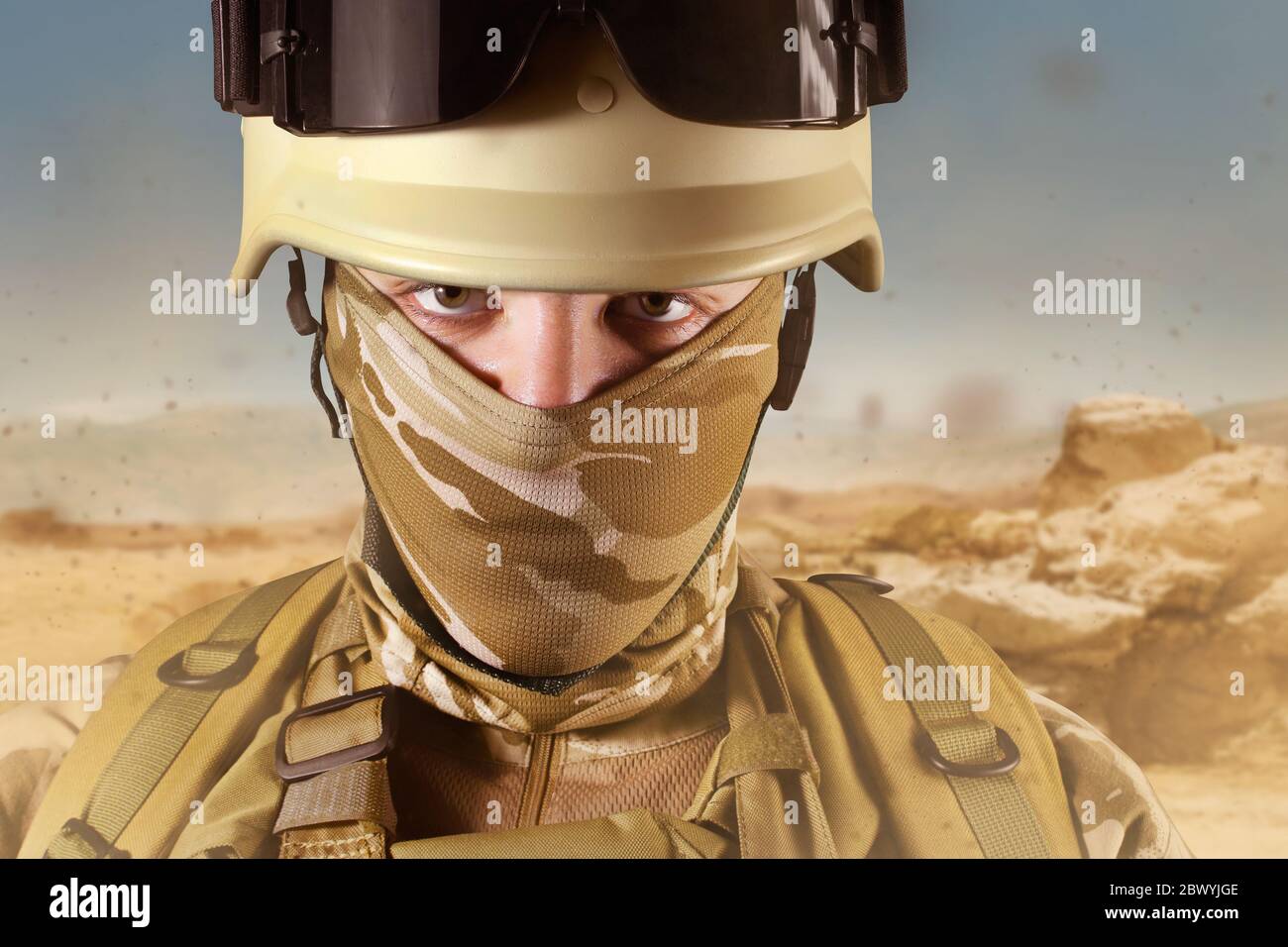 Photo of a fully equipped desert soldier in helmet on dusty desert ...