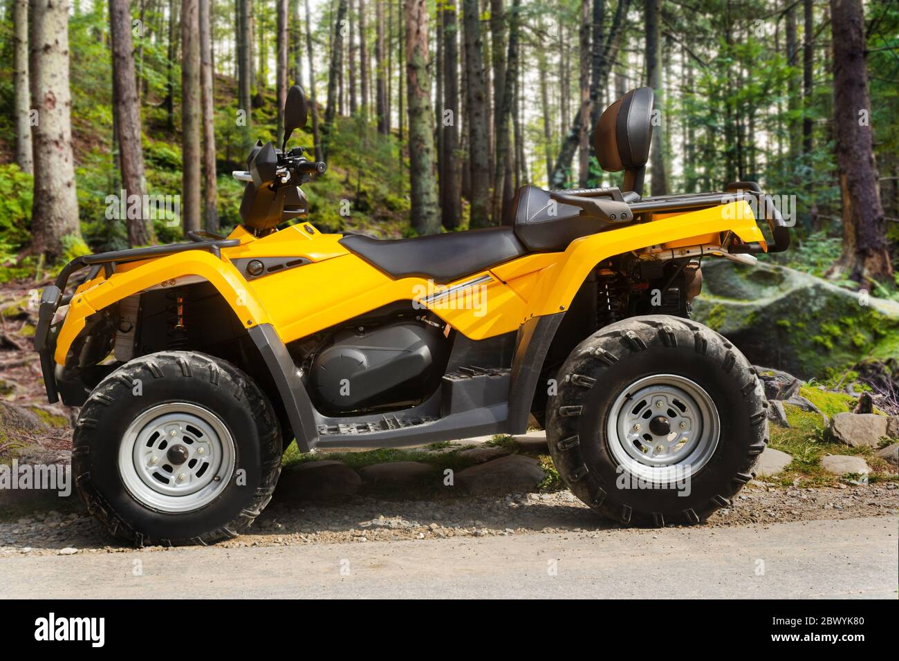 Photo of a yellow offroad touring atv vehicle standing in forest ...