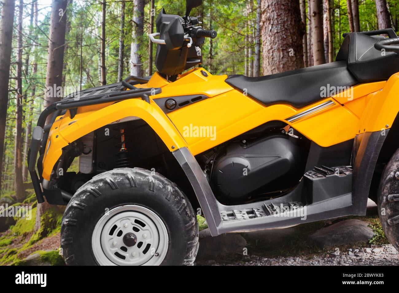 Photo of a yellow offroad touring atv vehicle standing in forest ...