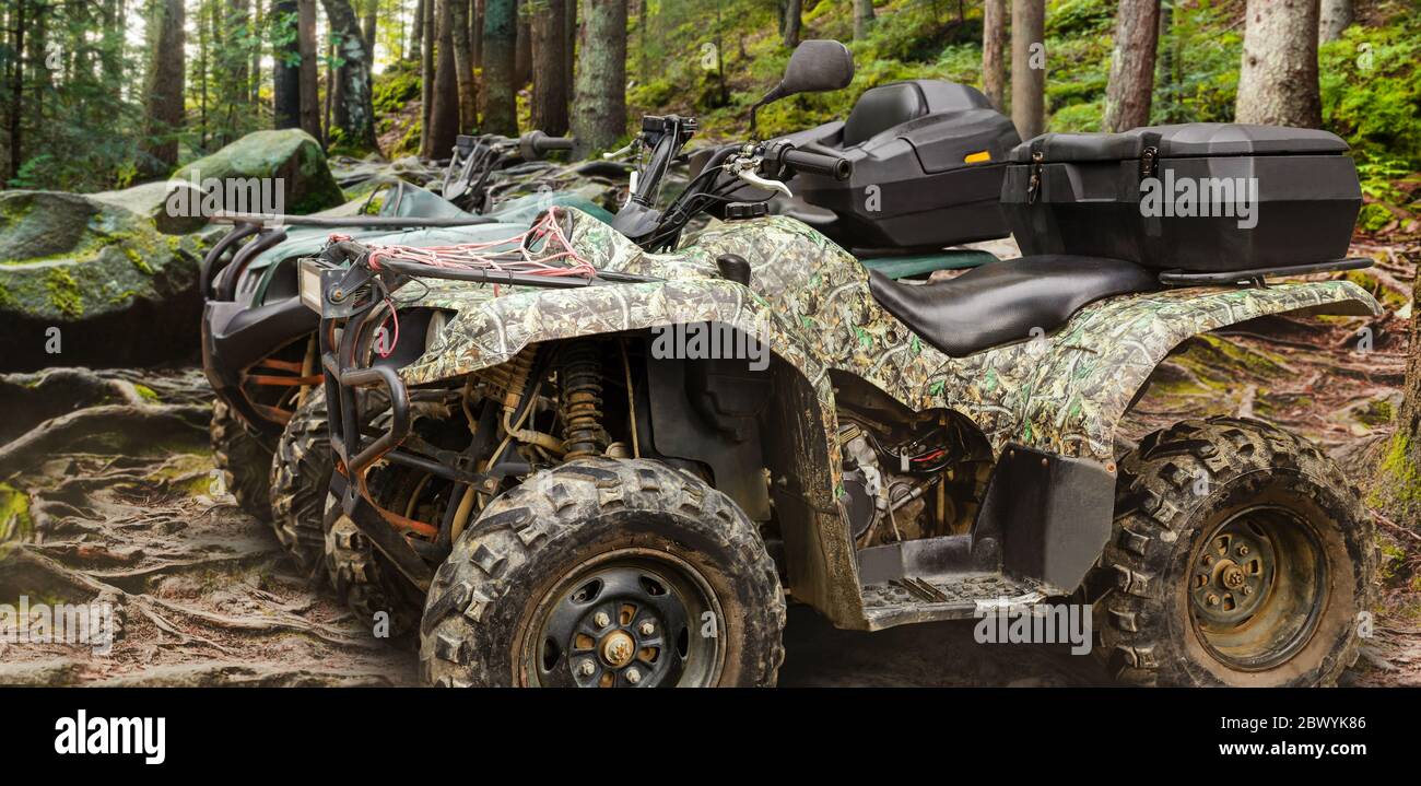 Photo of a camouflaged hunting offroad atv vehicles standing in forest ...