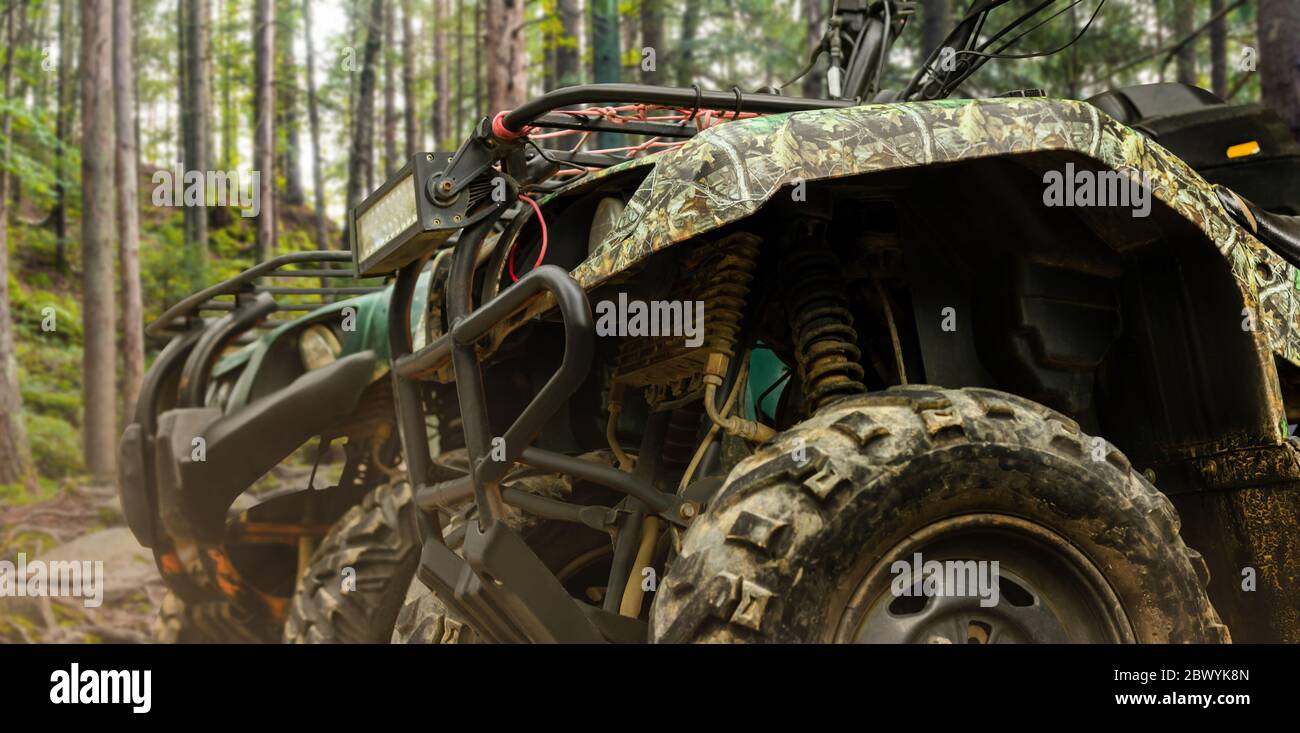 Photo of a camouflaged hunting offroad atv vehicles standing in forest ...