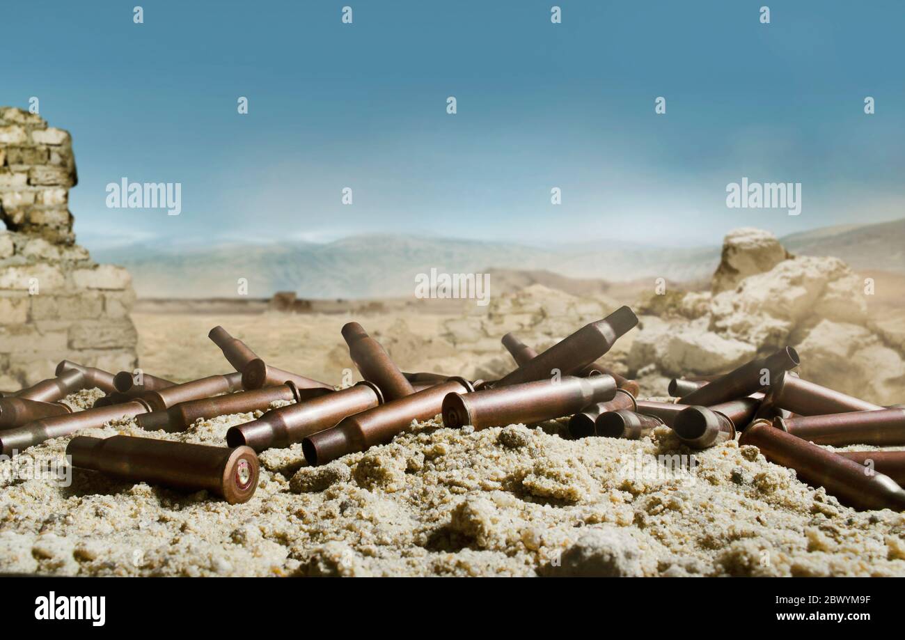 Photo of metal automatic rifle gun shells laying on sand, battlefield ...