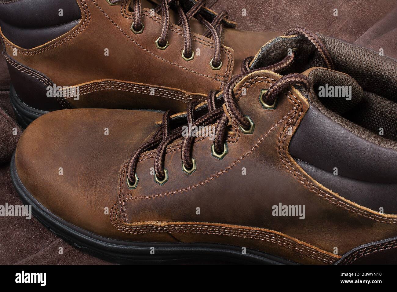 Traveling and working boots standing on leather sheet background upper ...