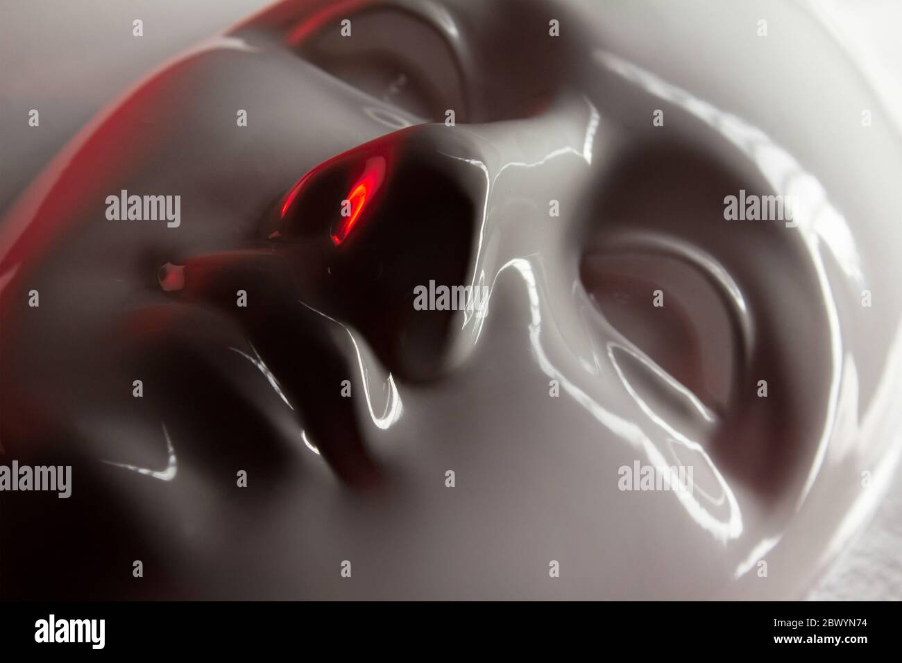 Photo of a white plastic human mask shape with red highlights angle ...