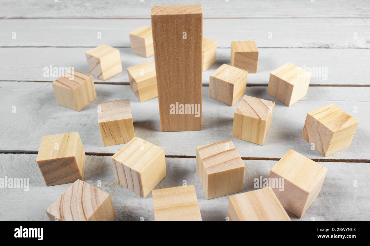 Concept photo of a small wooden blocks surrounding a bigger block on ...