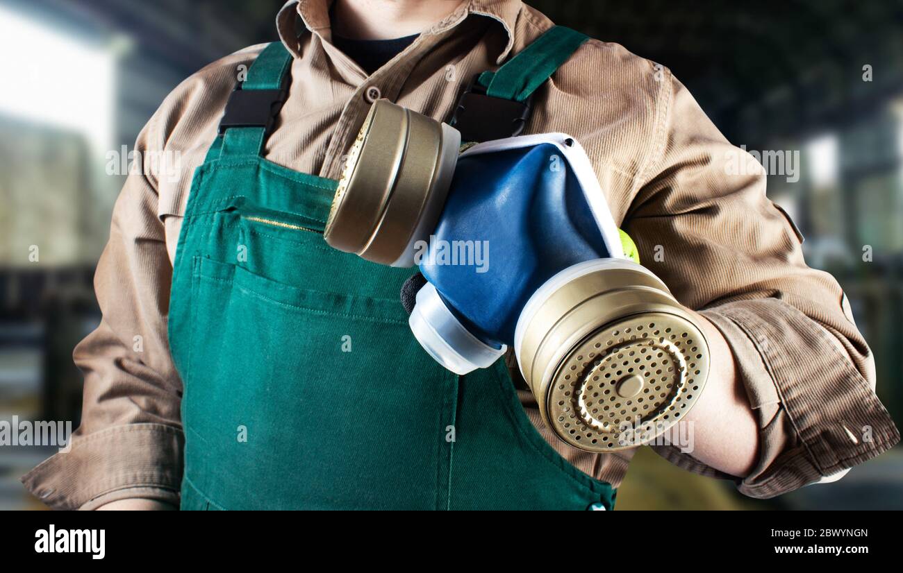 Photo of a worker in green overall outfit with protective gloves ...
