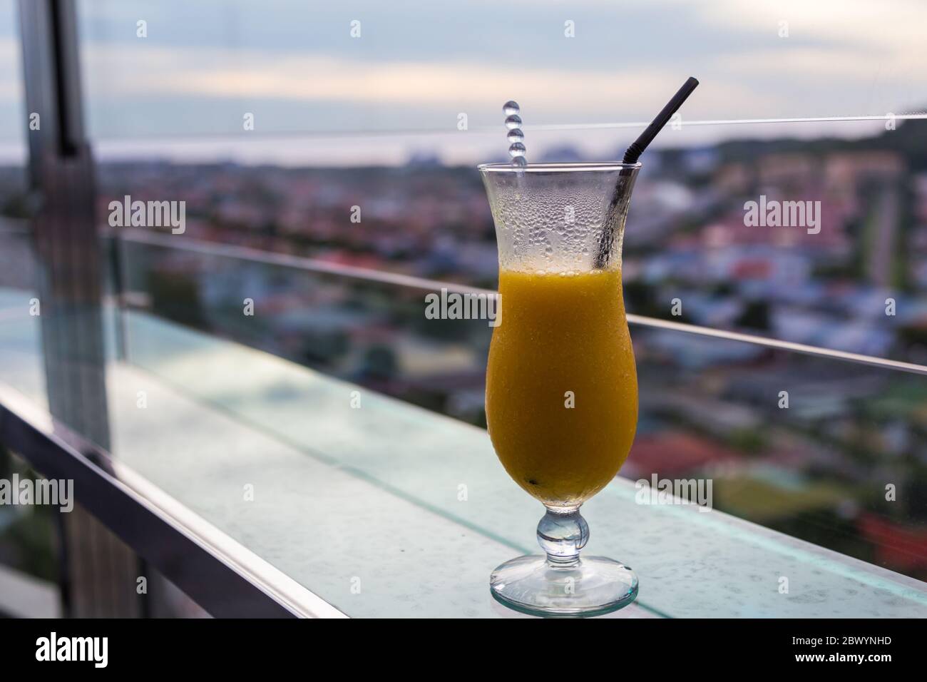 Fresh fruit juice cocktail on table in rooftop bar with city view ...