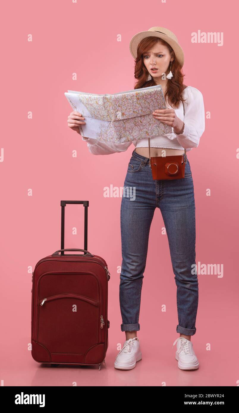 Confused Tourist Girl Holding Map Standing With Suitcase In Studio ...