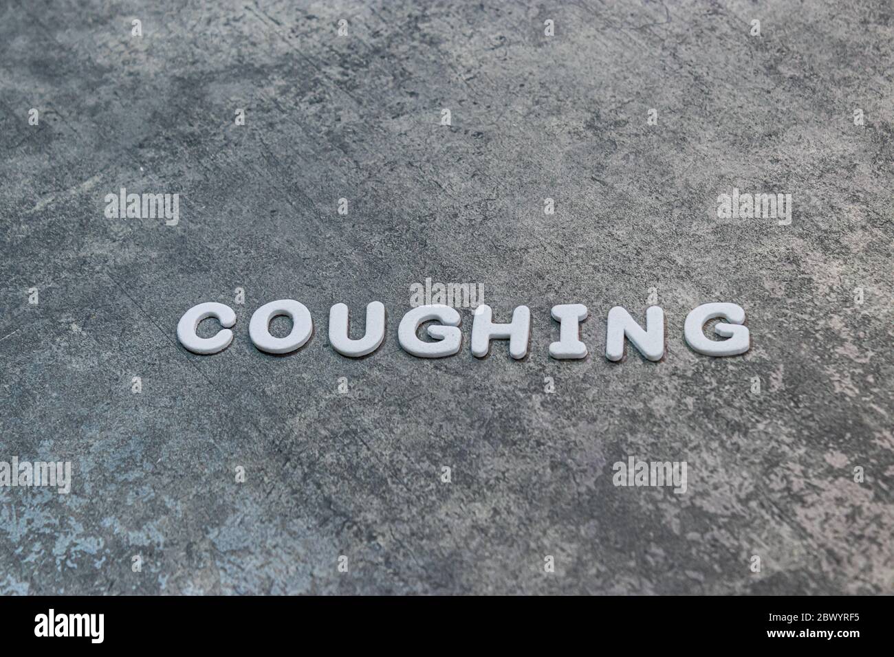 coughing written out on gray background with white lettering centered ...