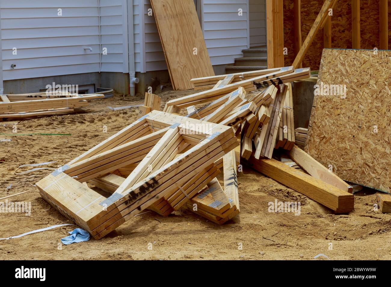 House under construction of stack unloading wooden beams on ...