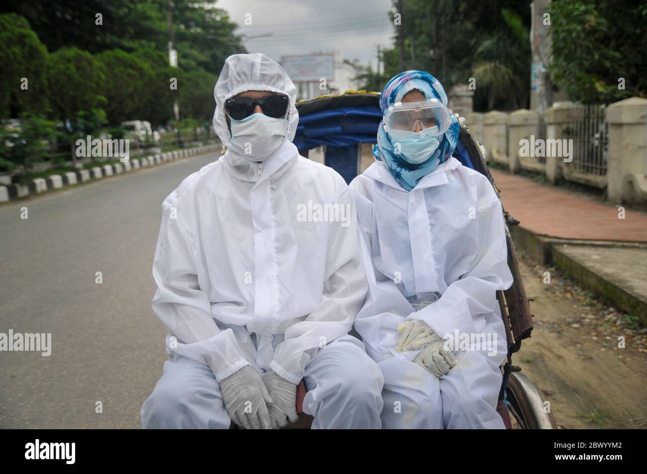 Two people wearing mask and PPE kits as a preventive measure against ...