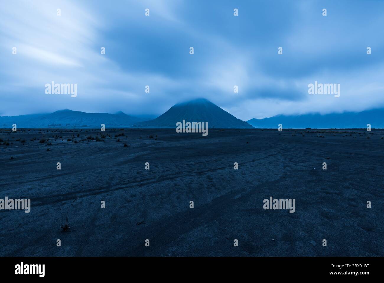 view of Mount Bromo under cloudy sky with the sand sea Stock Photo - Alamy