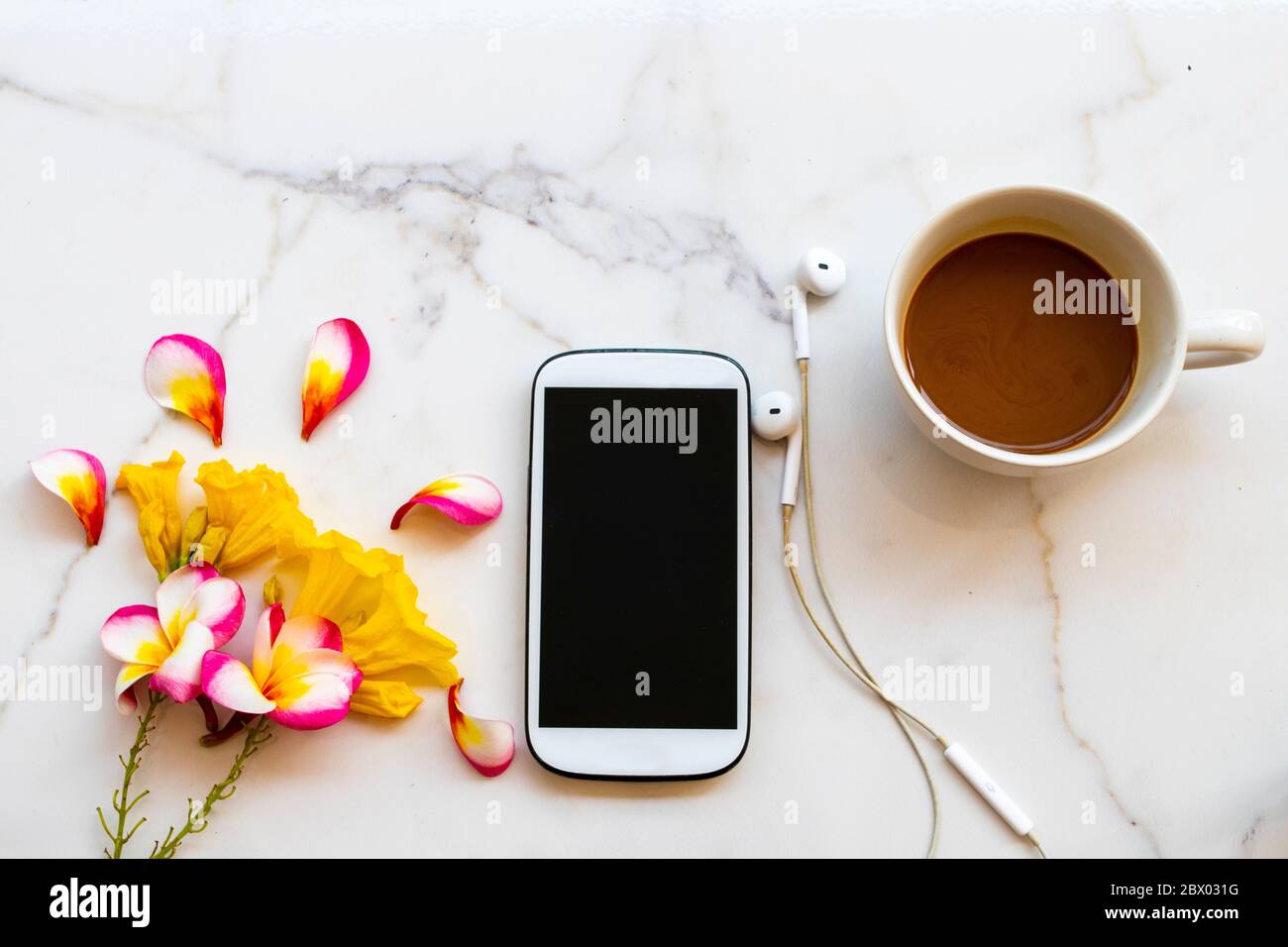 mobile phone ,earphone ,hot coffee and yellow flowers ,frangipani of ...