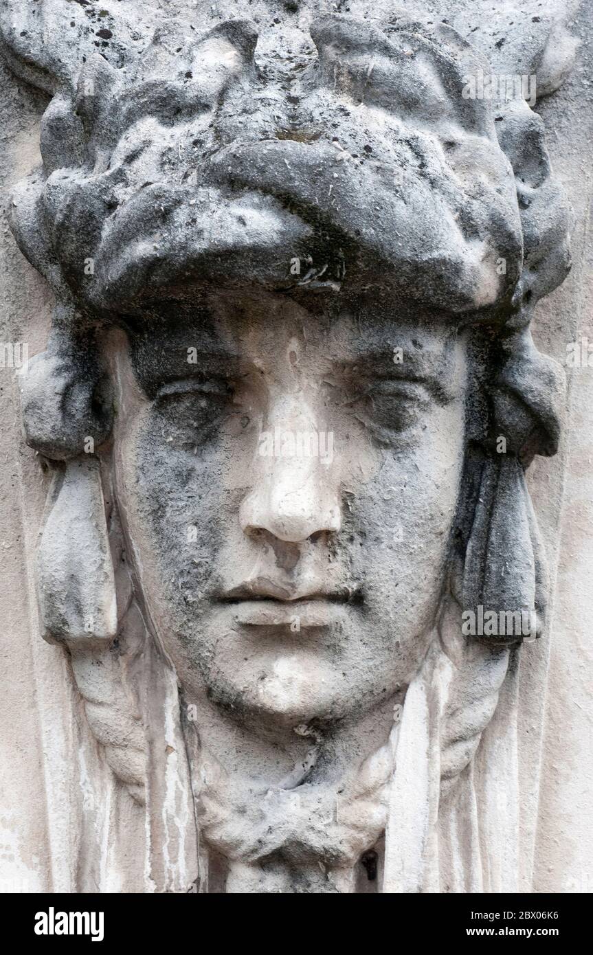 A Close Up Of A Stone Head Carved On The Exterior Of A Building In ...