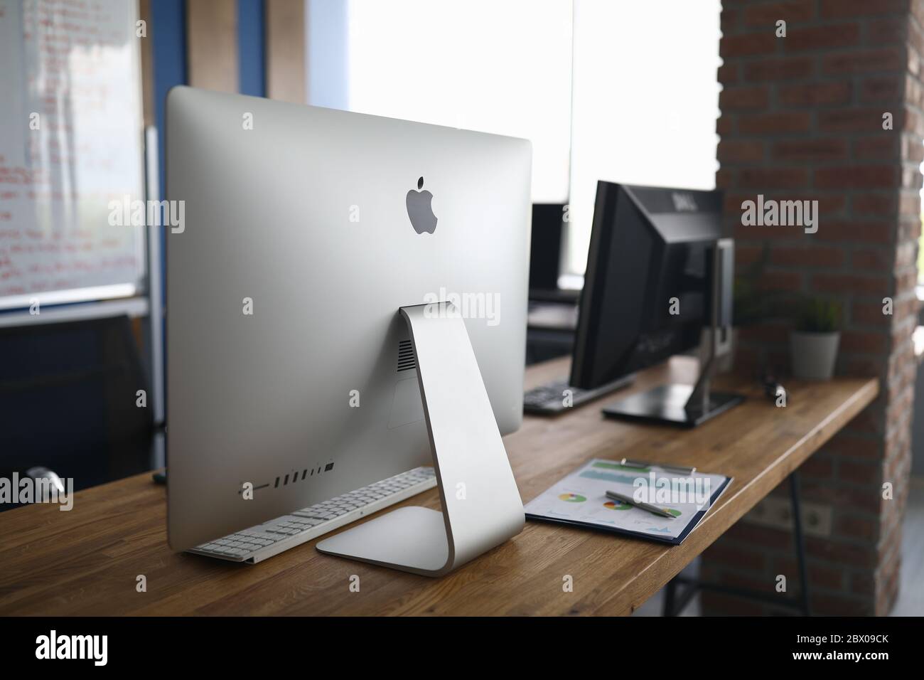Apple Imac pc against empty office background Stock Photo - Alamy